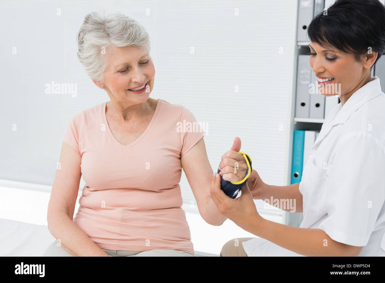 Female doctor fixing wrist brace on senior patients hand Stock Photo ...