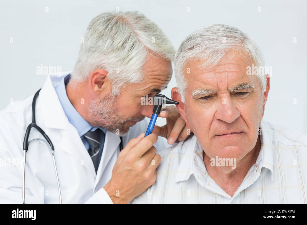 Doctor checking patient's ear hi-res stock photography and images - Alamy