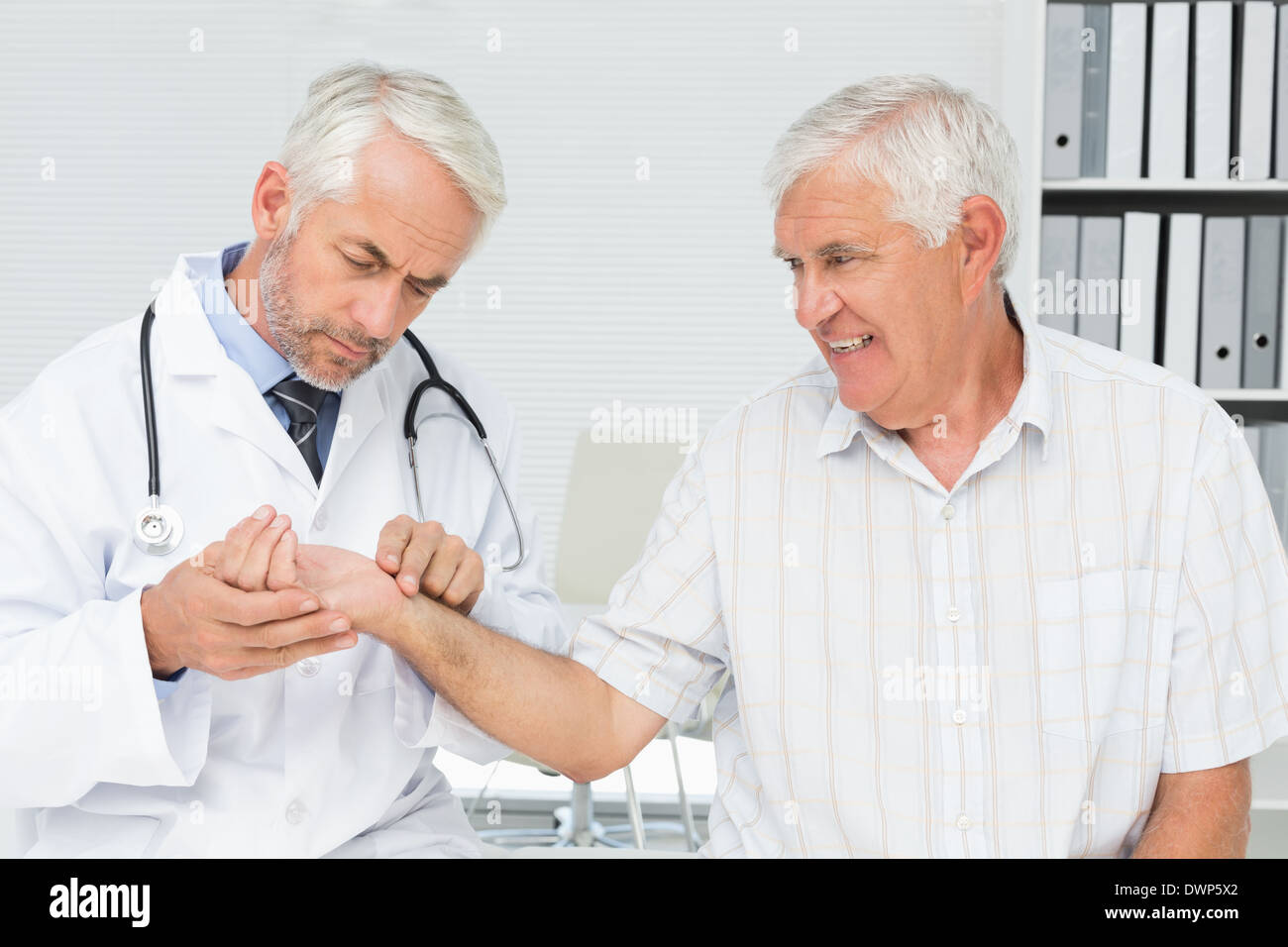 Male doctor taking a senior patients pulse Stock Photo - Alamy