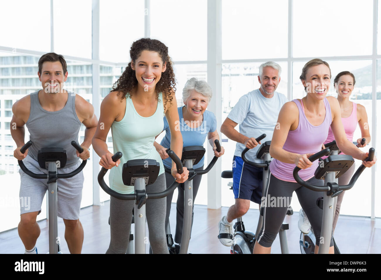 Happy people working out at spinning class Stock Photo - Alamy