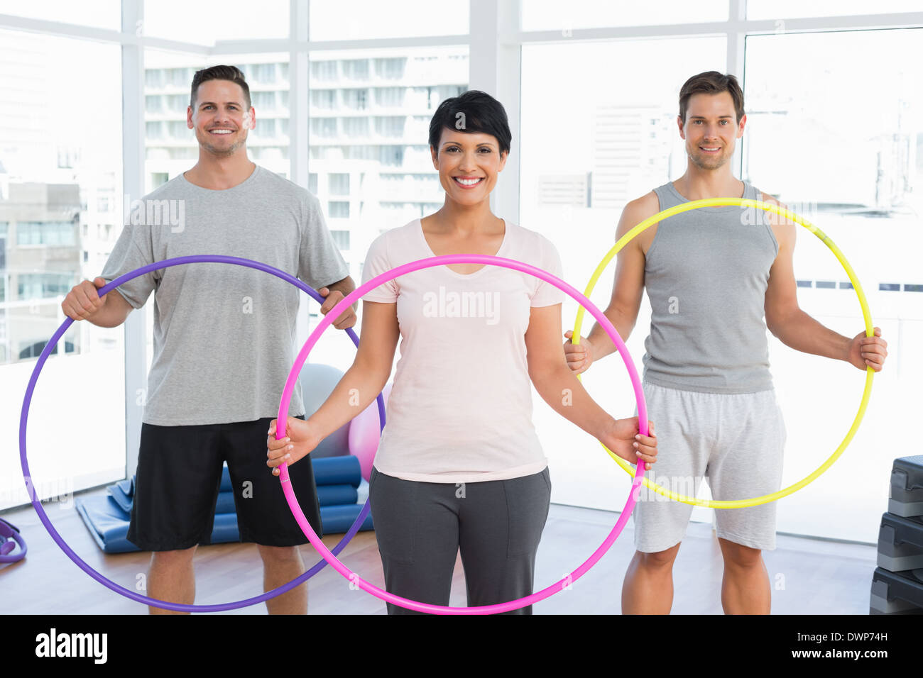 Fitness class holding hula hoops in gym Stock Photo - Alamy