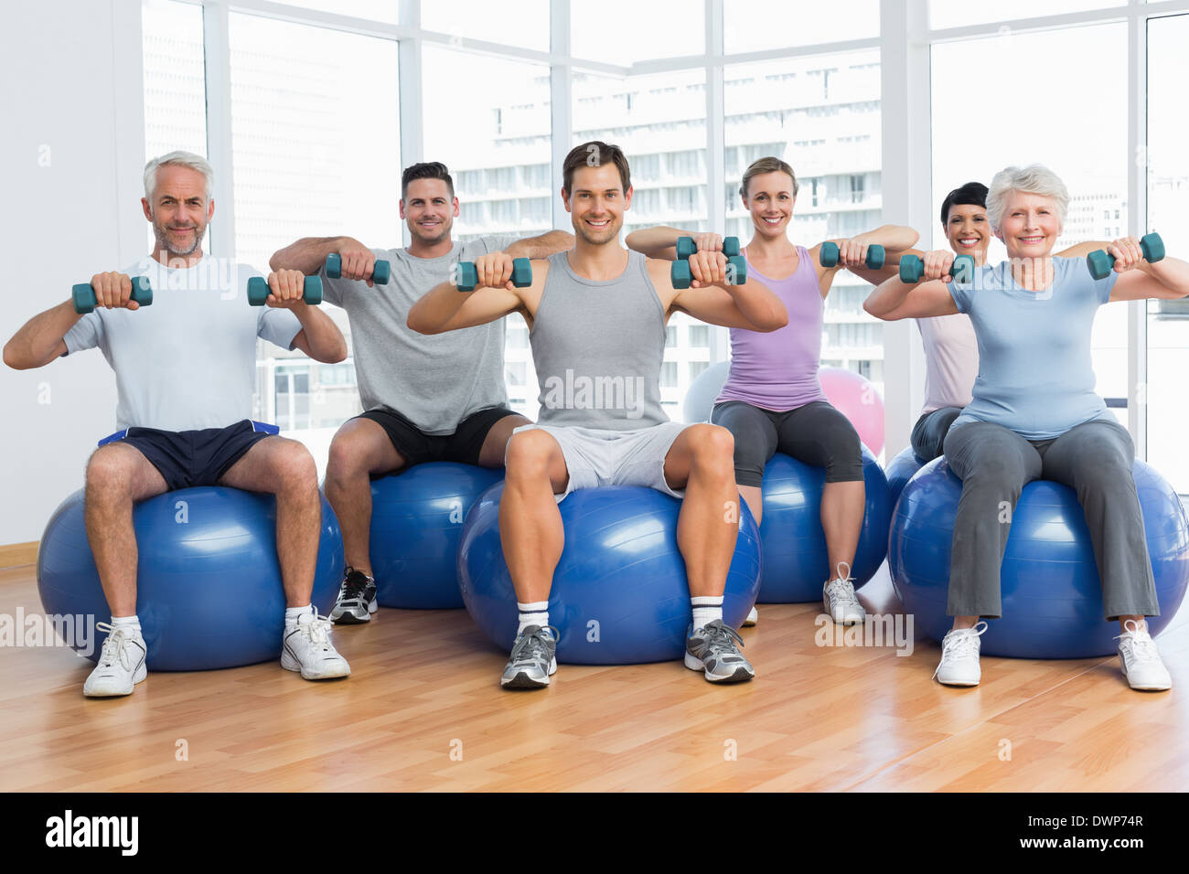Fitness class with dumbbells sitting on exercise balls in gym Stock ...