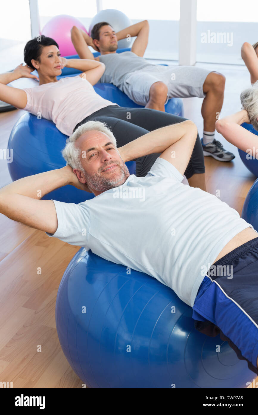 Smiling people stretching on exercise balls in gym Stock Photo - Alamy