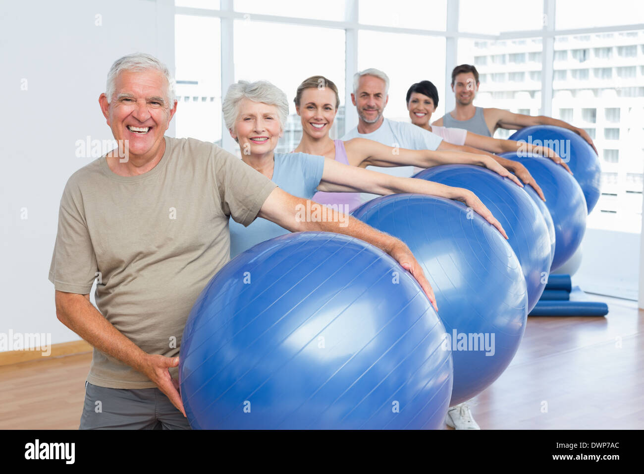 Sporty people carrying exercise balls in bright gym Stock Photo - Alamy