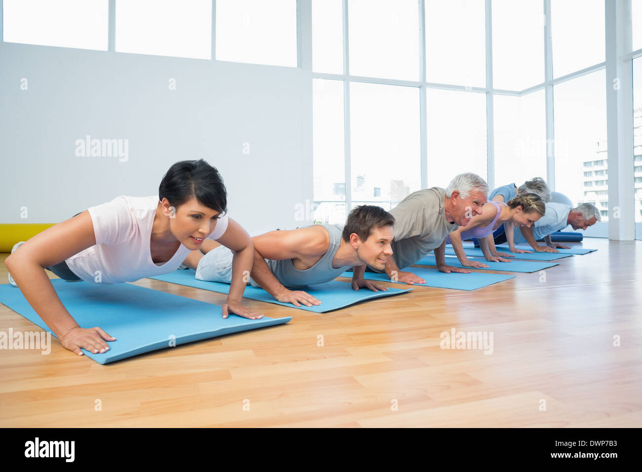 Group doing push ups in row at yoga class Stock Photo - Alamy