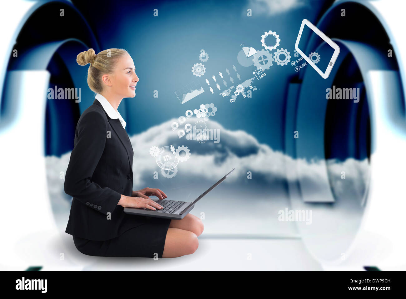 Blonde businesswoman sitting using laptop with cogs and wheels Stock ...
