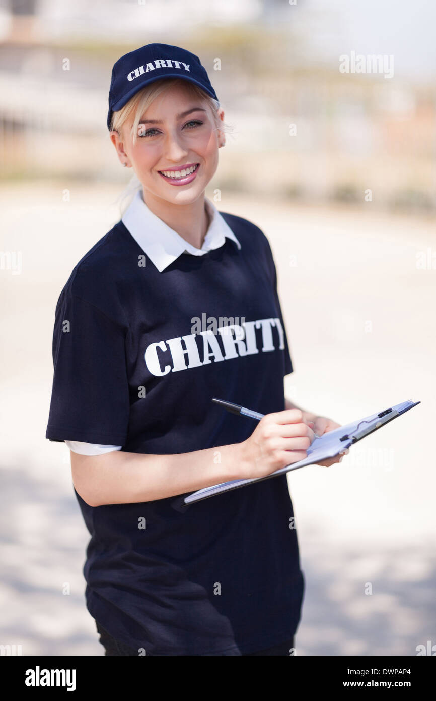 beautiful young charity worker writing on clipboard on the street Stock ...