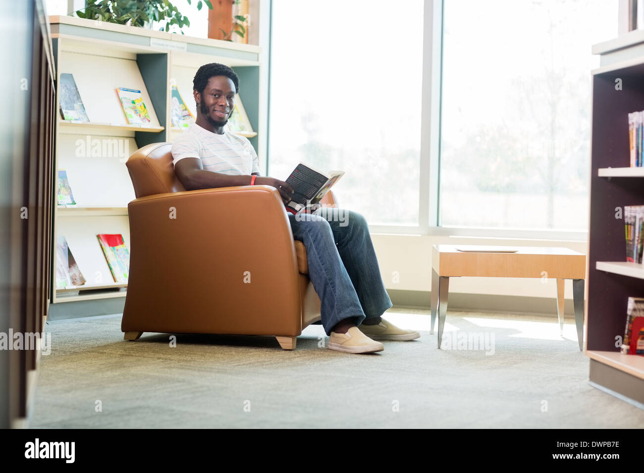Young Student Reading Book In Library Stock Photo - Alamy