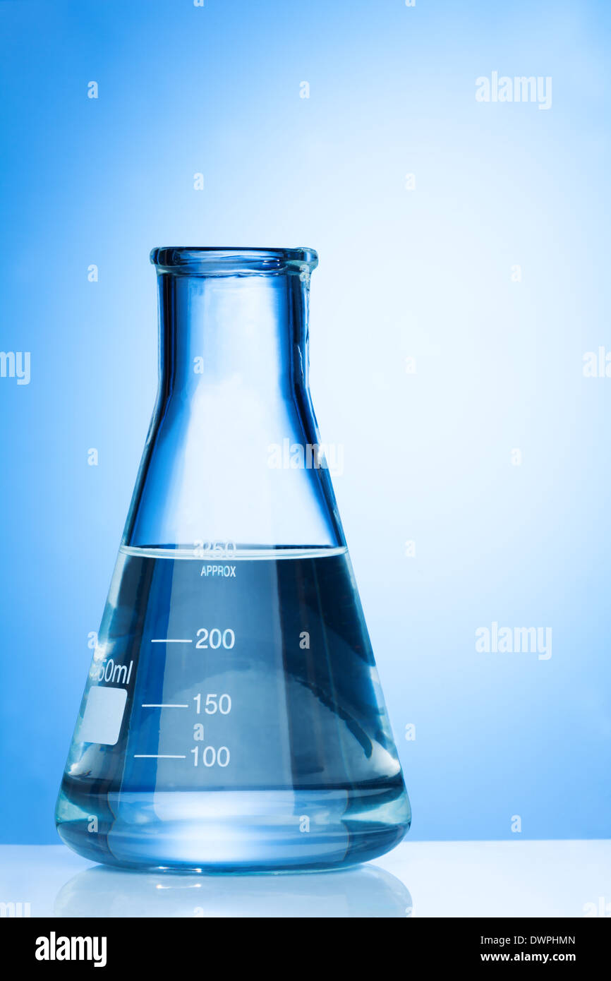 Blue flask in laboratory environment standing on the table with liquid ...