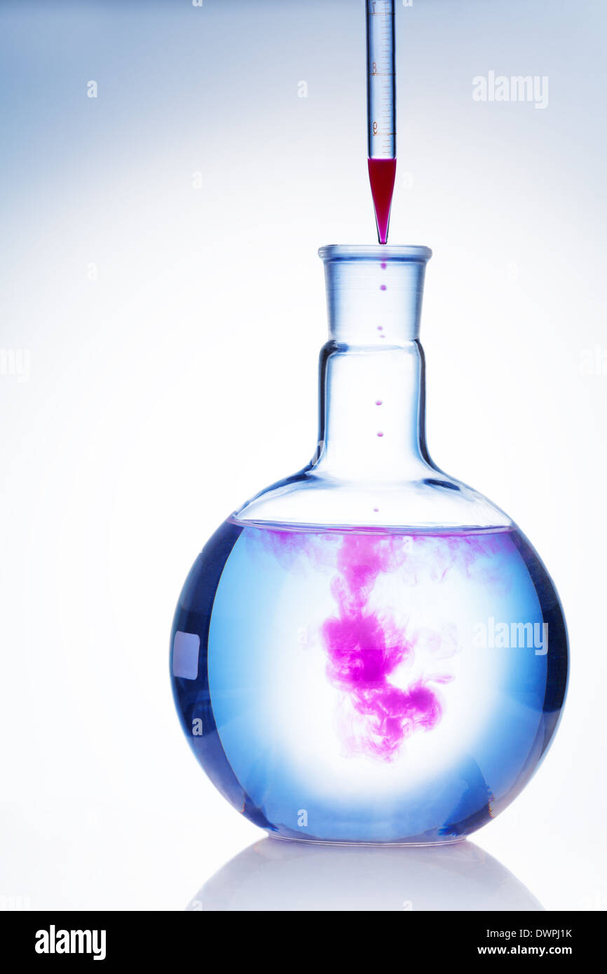 Drop of color in glass flask with liquid in laboratory Stock Photo - Alamy