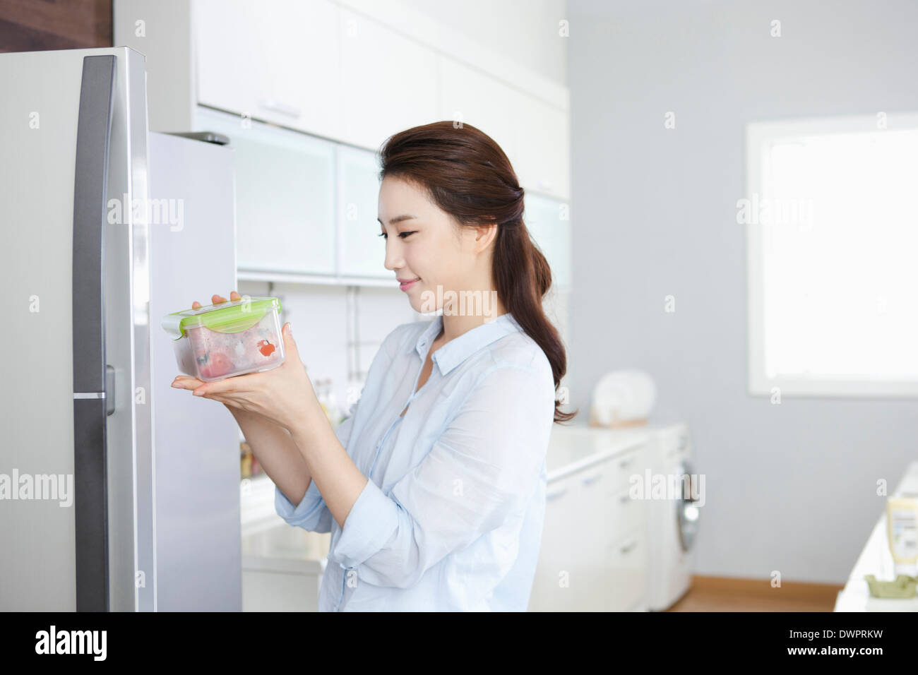a woman taking out food from refrigerator in the kitchen Stock Photo ...