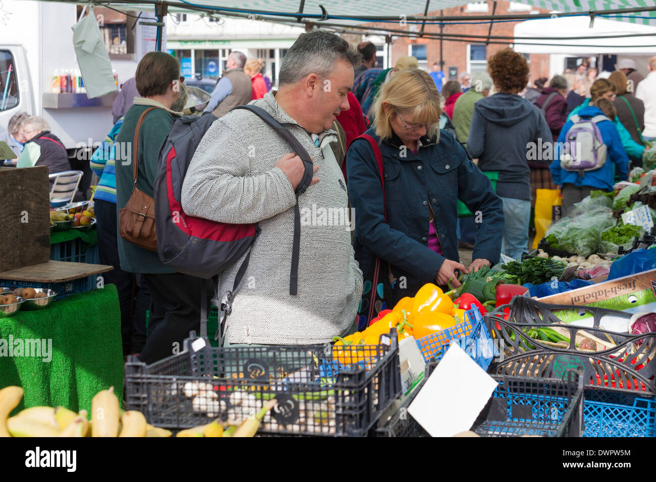 Customers selecting vegetables from market stall Stock Photo - Alamy