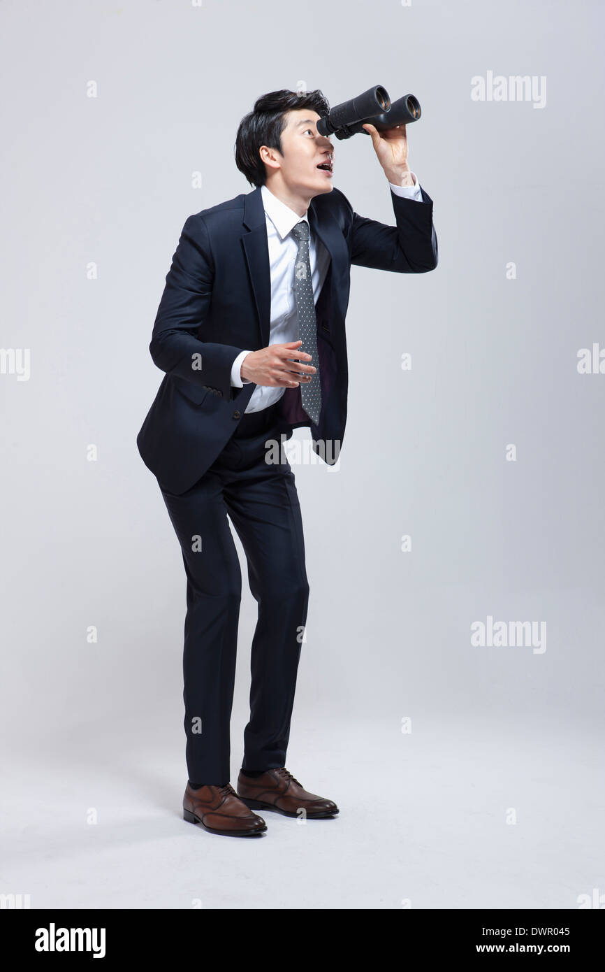 a businessman looking at something with binocular Stock Photo - Alamy