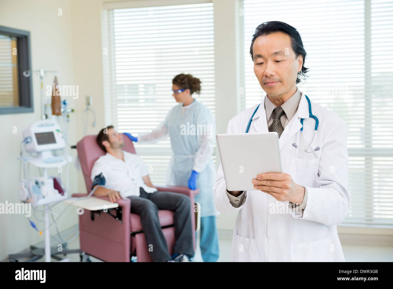 Doctor Using Digital Tablet In Chemo Room Stock Photo - Alamy