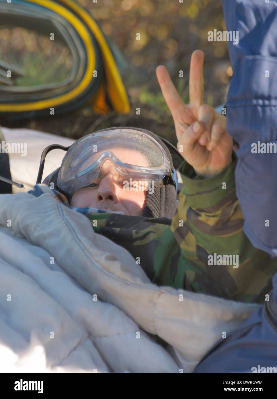 Protester giving victory sign whilst a 'lock-on' device is being ...