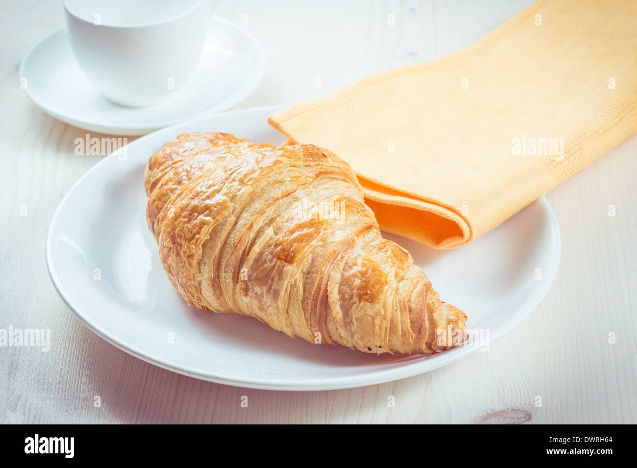 Fresh croissant on a plate. Toning in vintage style Stock Photo - Alamy