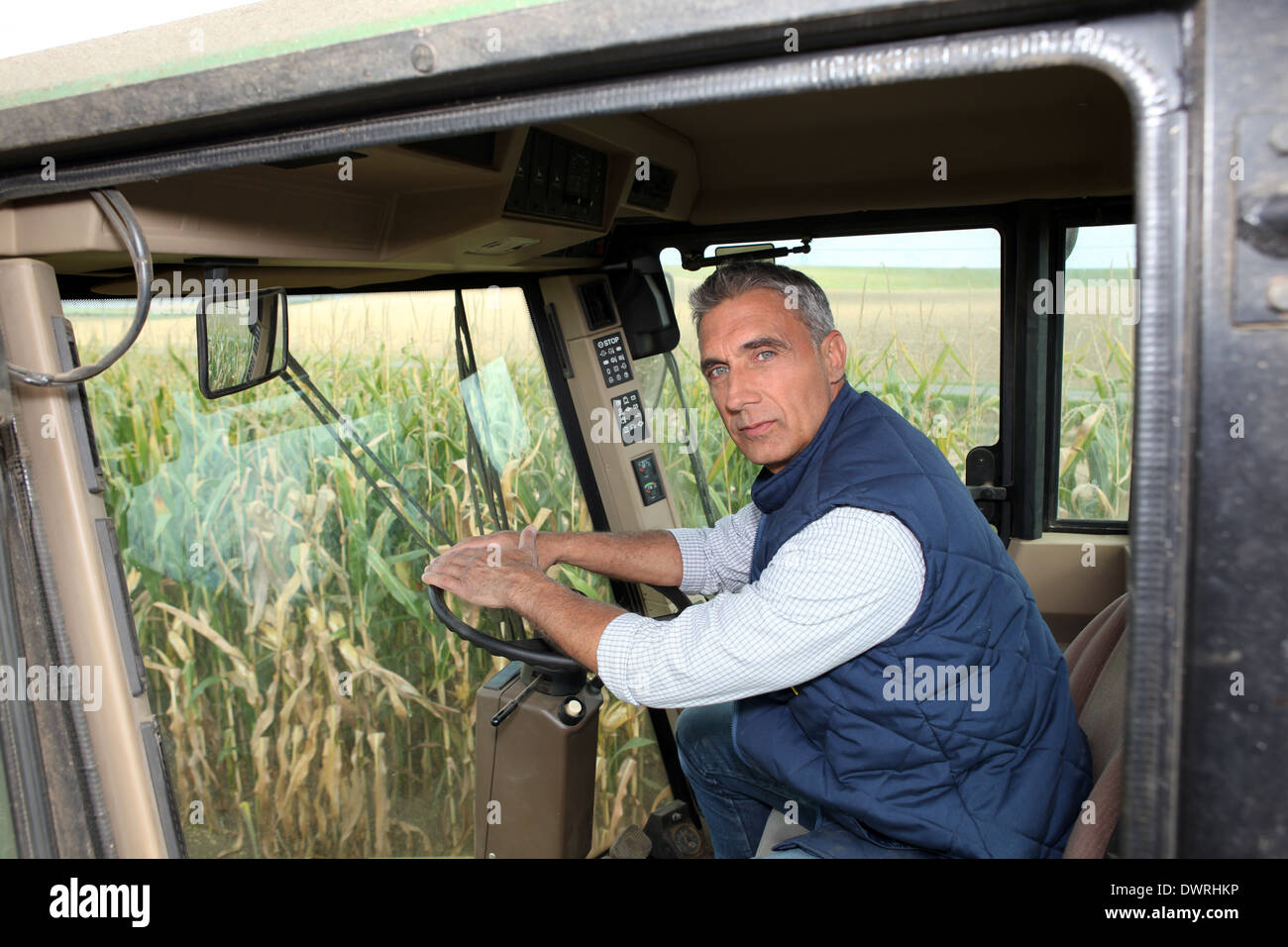 Farmer driving a tractor Stock Photo - Alamy
