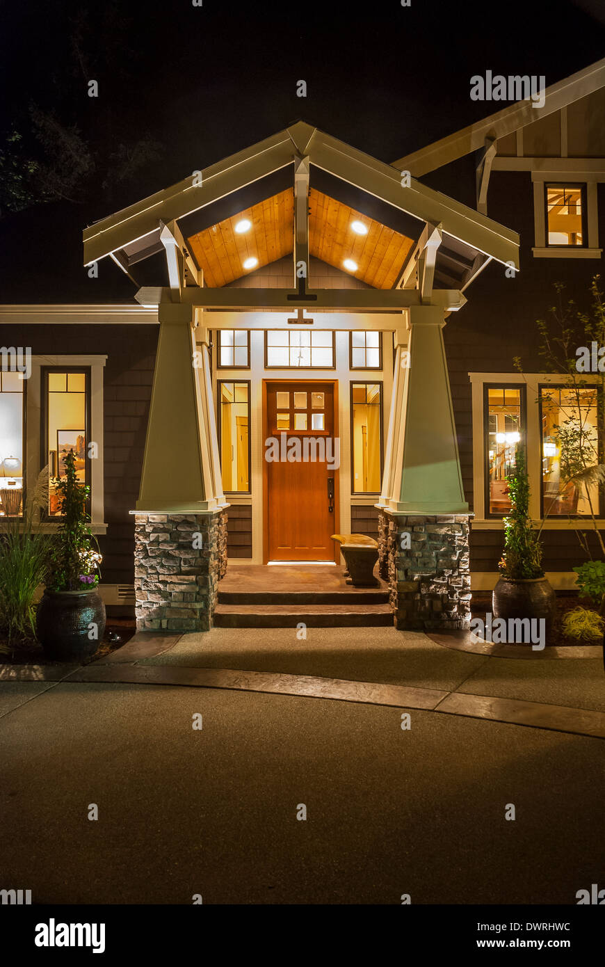 Front entranceway to luxury home after dark with lighting and a guest ...