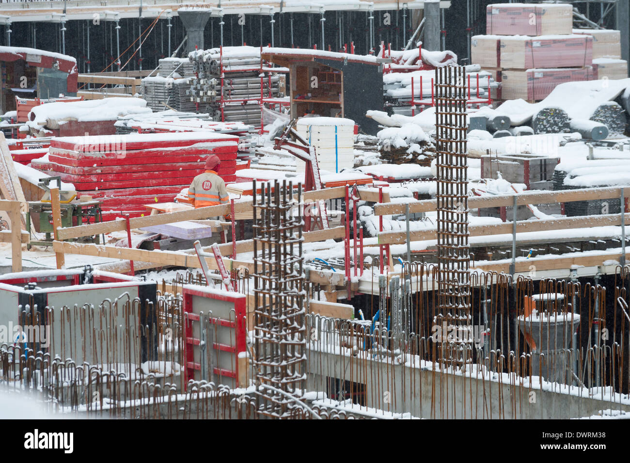 Construction workers and building activity on a snowed winter ...