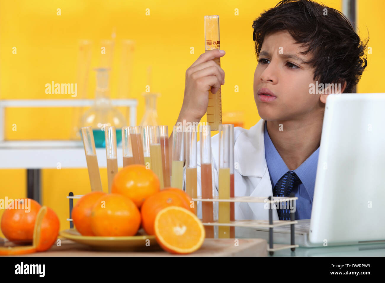 Boy analysing orange juice Stock Photo - Alamy