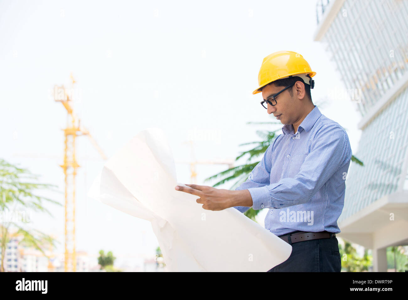 indian architect reading plans on construction site Stock Photo - Alamy