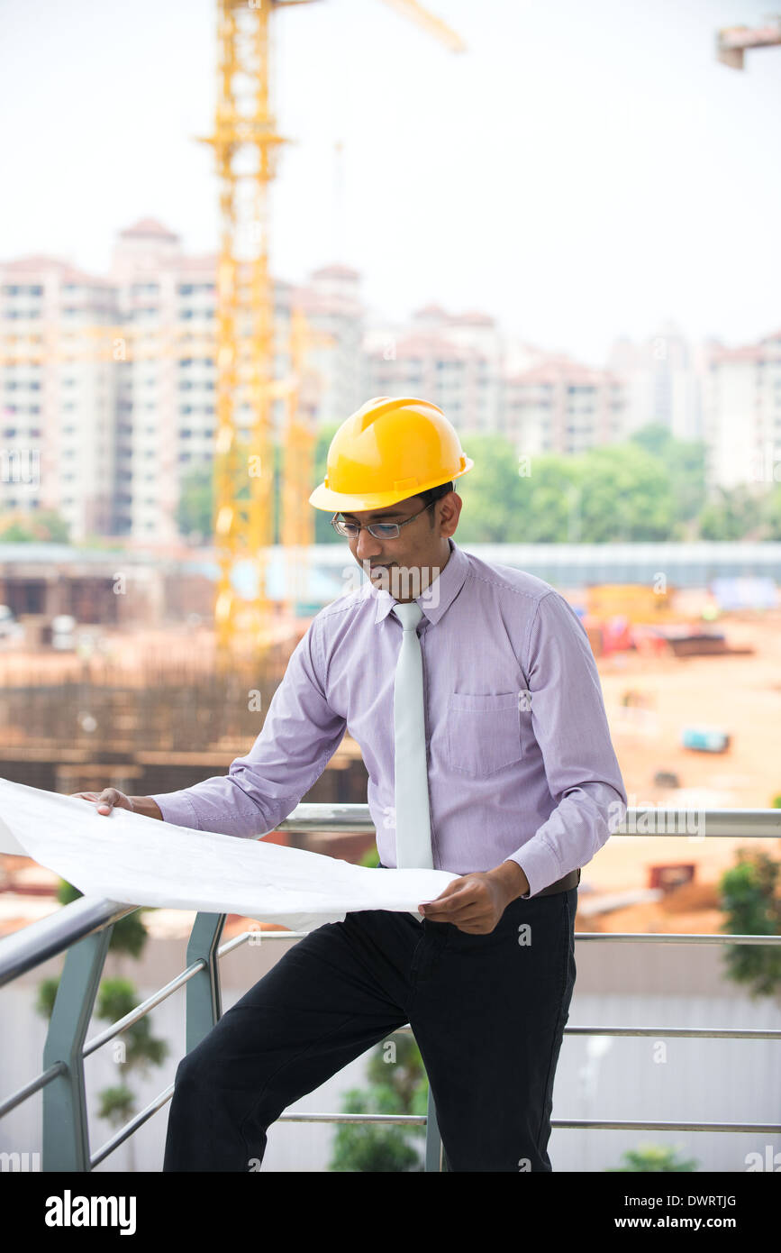indian male architect reading plans with construction background Stock ...