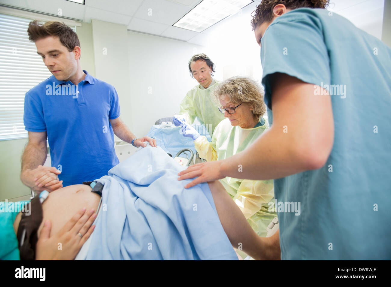 Medical Team Examining Pregnant Woman During Delivery In Operati Stock ...