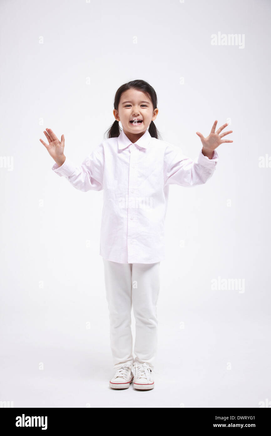 a kid in white outfit making faces Stock Photo - Alamy
