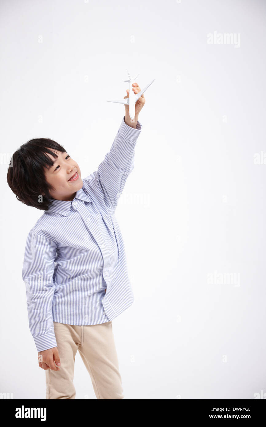 a kid playing with plane toy in white background Stock Photo - Alamy