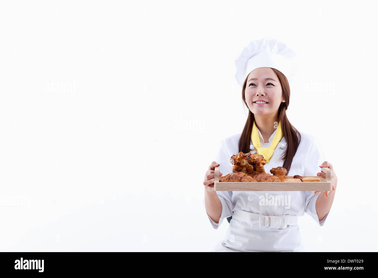 a female pastry chef holding a tray of bread Stock Photo - Alamy