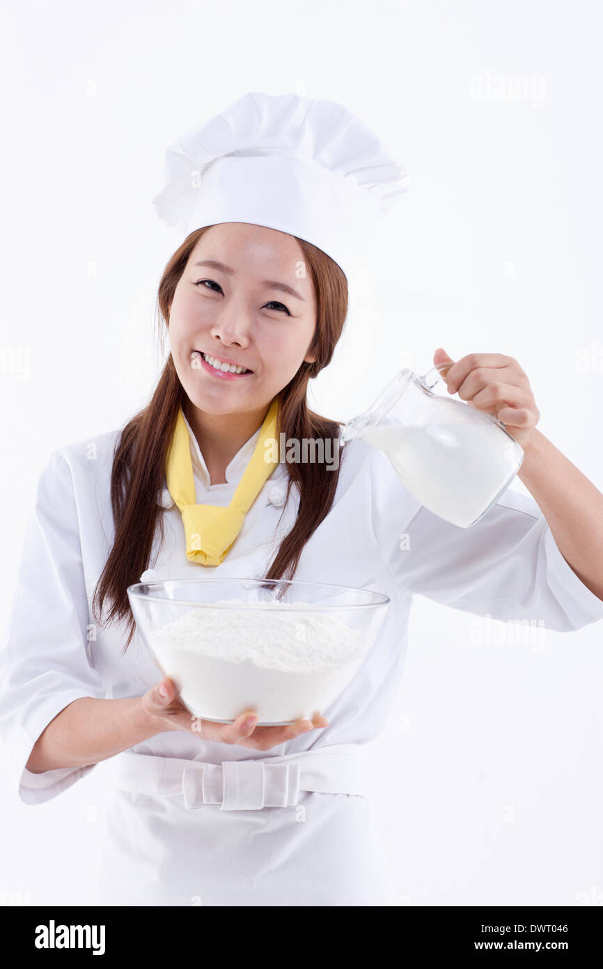 a female pastry chef pouring milk on flour Stock Photo - Alamy