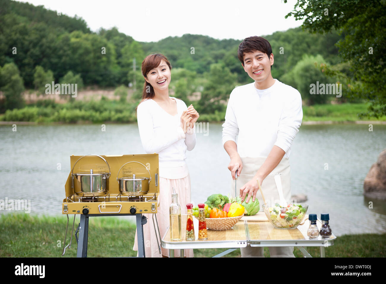 a couple cooking in camping area Stock Photo - Alamy