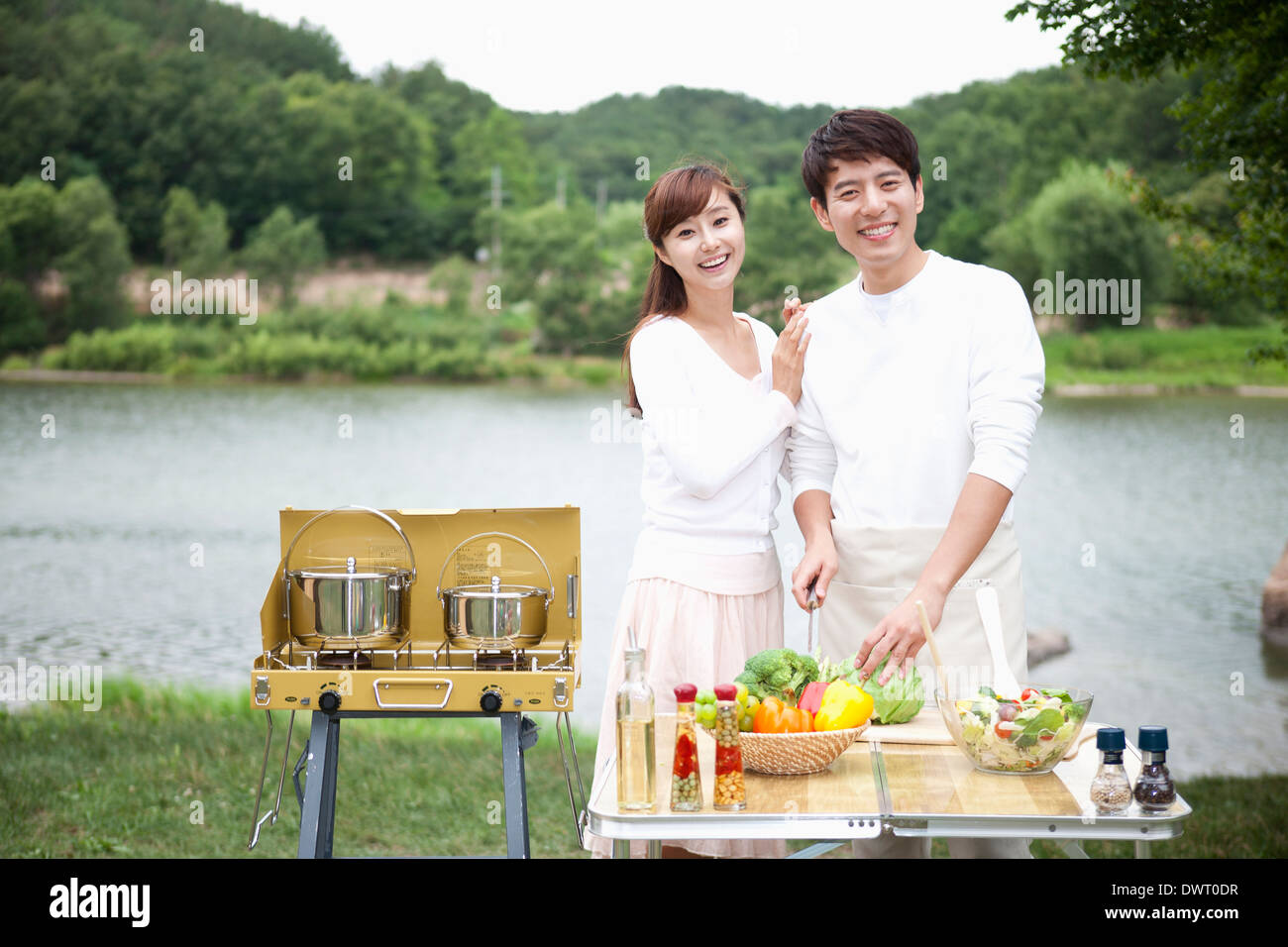 a couple cooking in camping area Stock Photo - Alamy