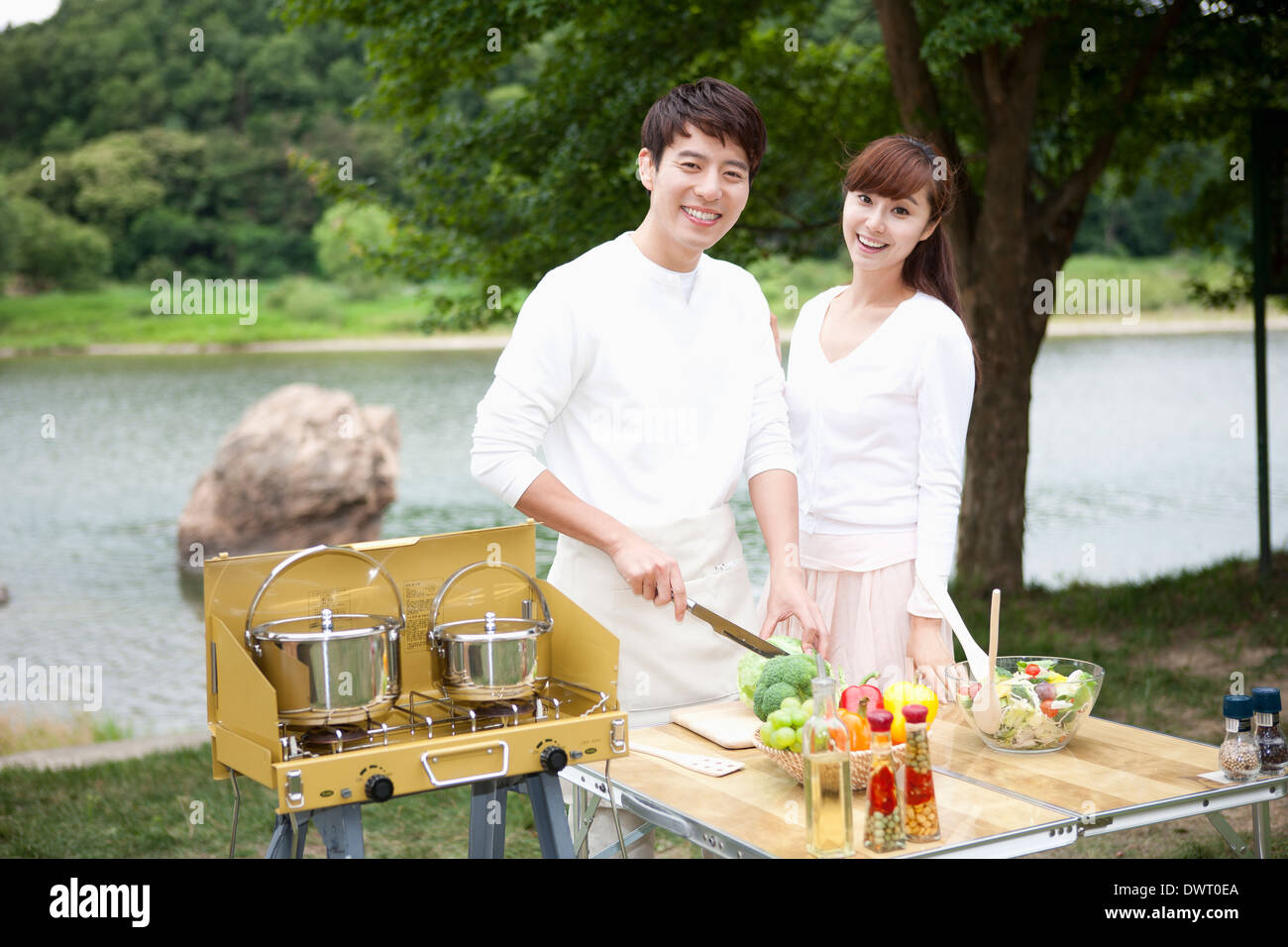 a couple cooking in camping area Stock Photo - Alamy