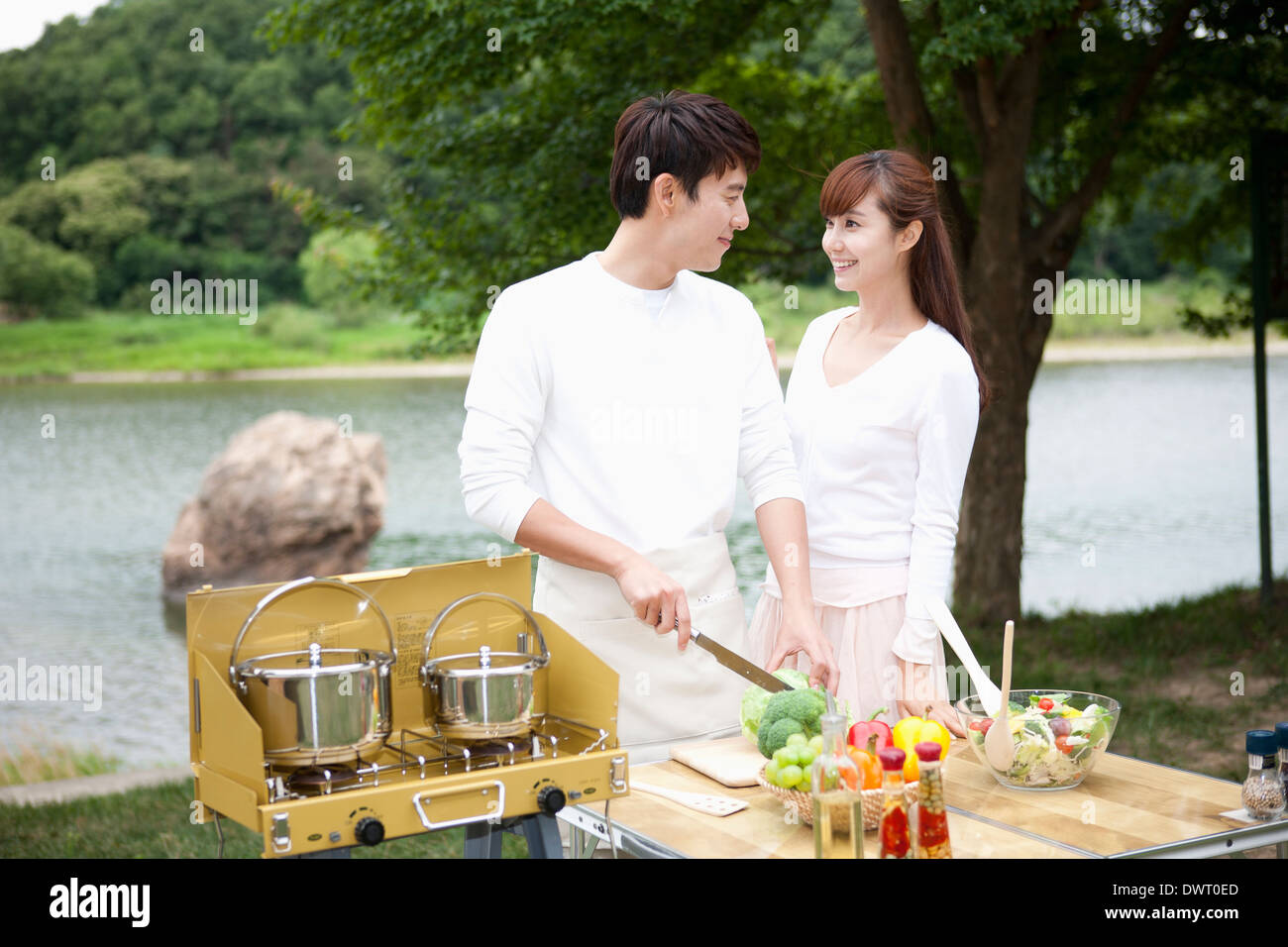 a couple cooking in camping area Stock Photo - Alamy