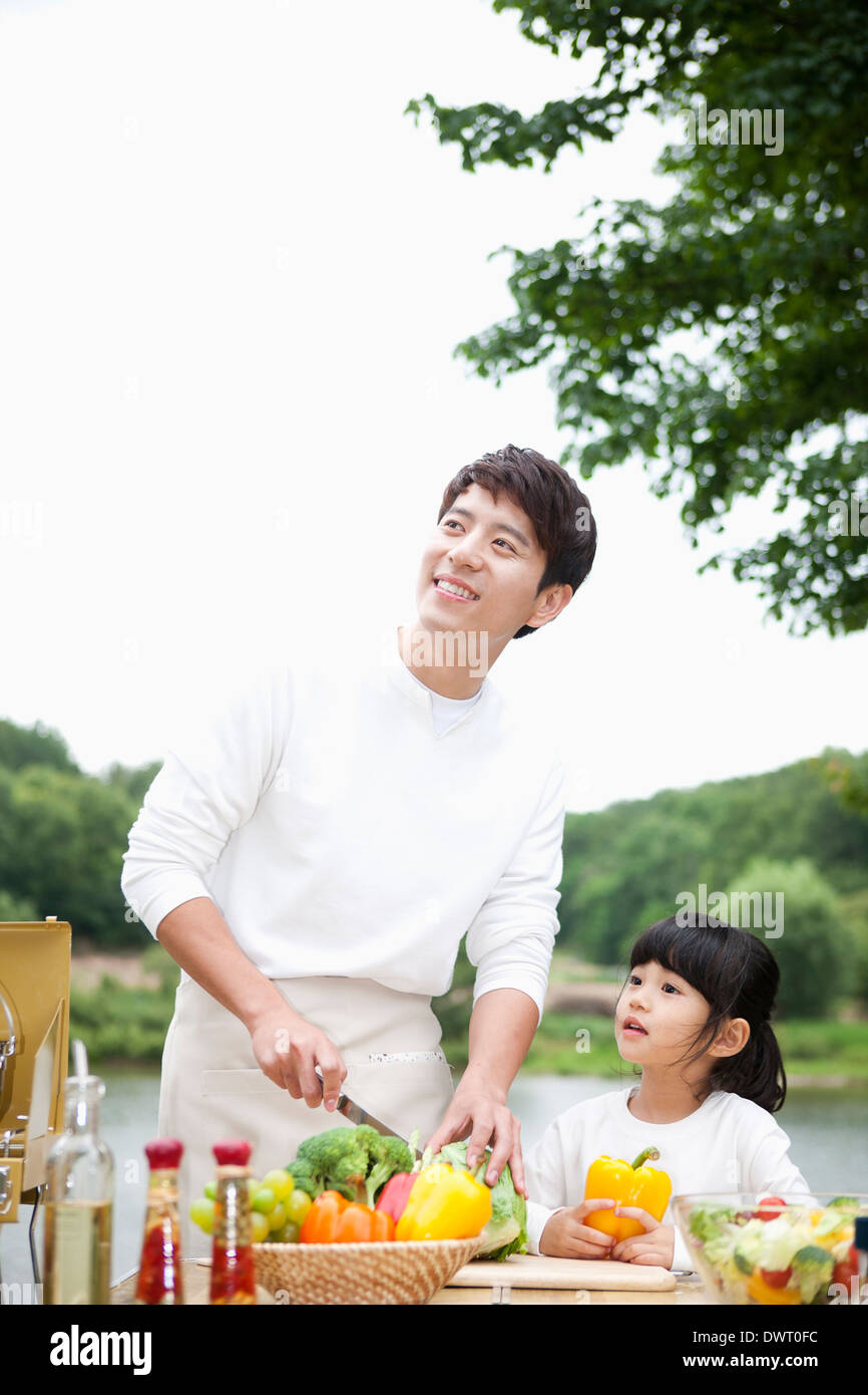 a father and daughter cooking together in camping area Stock Photo - Alamy