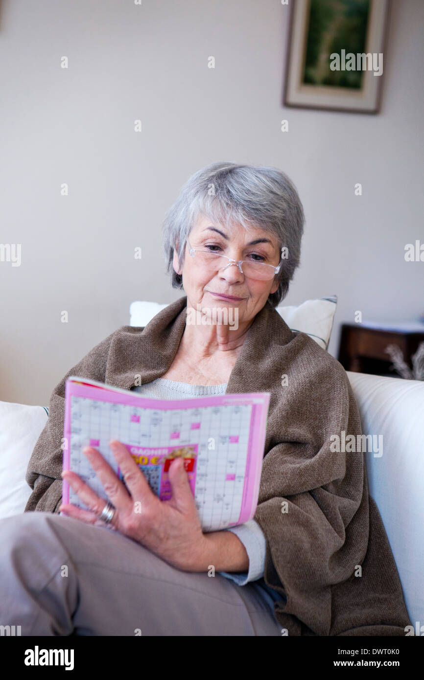 Elderly person doing cr-word puzzle Stock Photo - Alamy