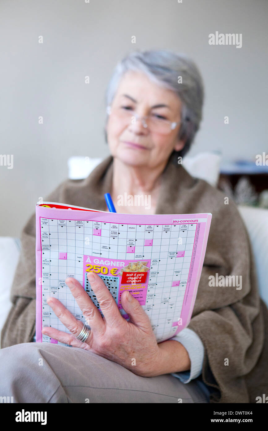 Elderly person doing cr-word puzzle Stock Photo - Alamy