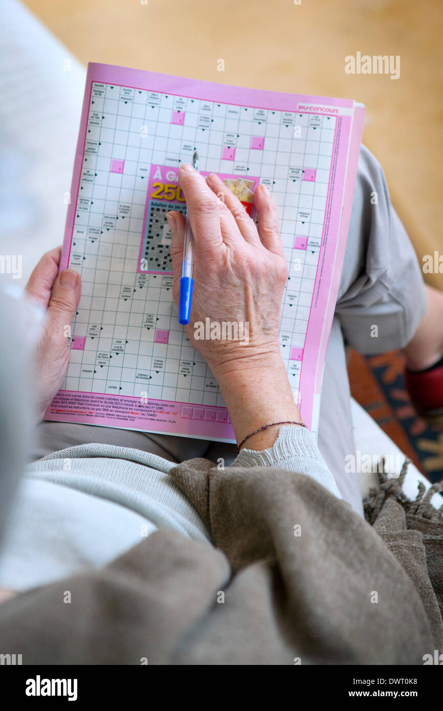 Elderly person doing cr-word puzzle Stock Photo - Alamy