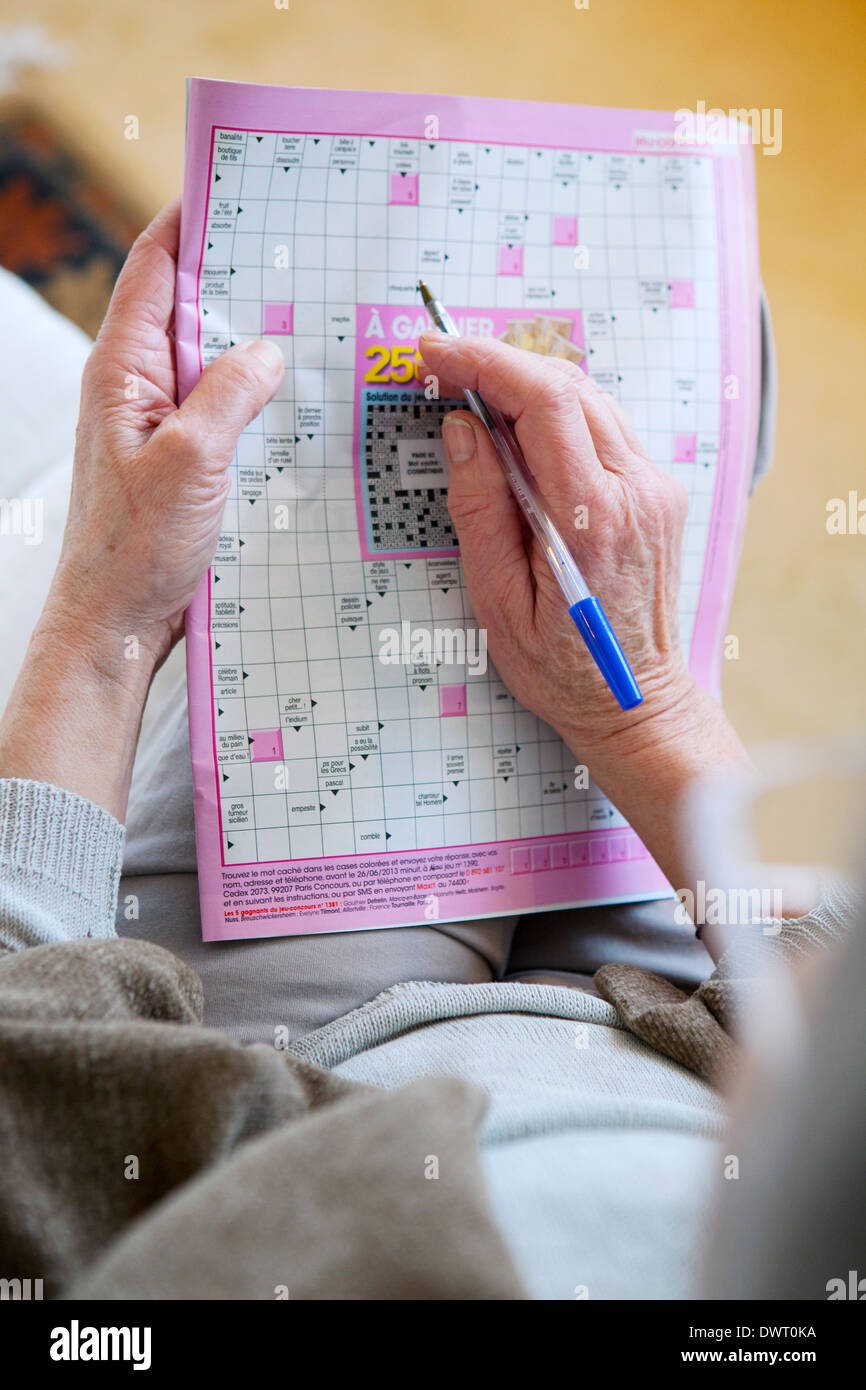 Elderly person doing cr-word puzzle Stock Photo - Alamy
