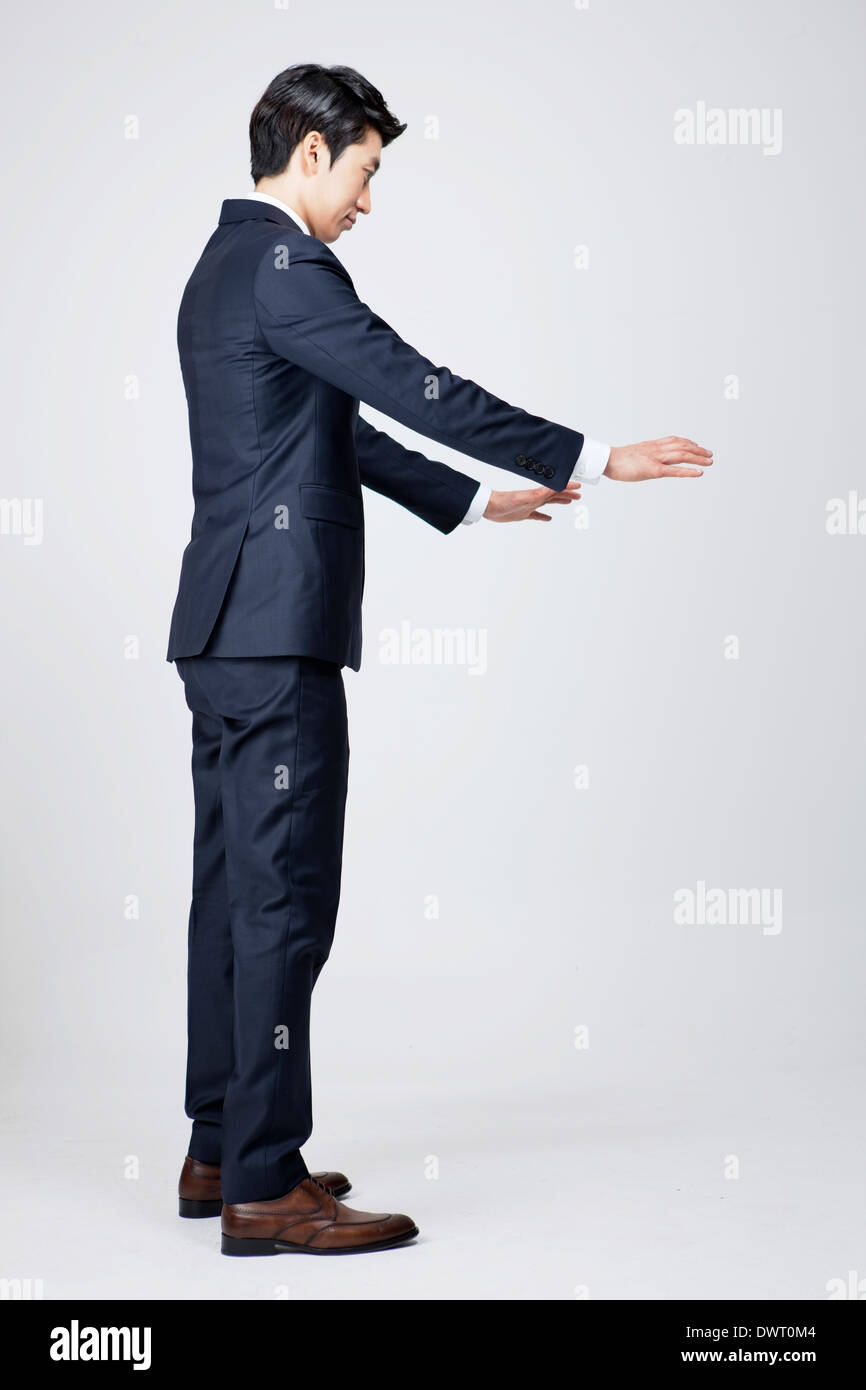 a businessman posing down to get something Stock Photo - Alamy