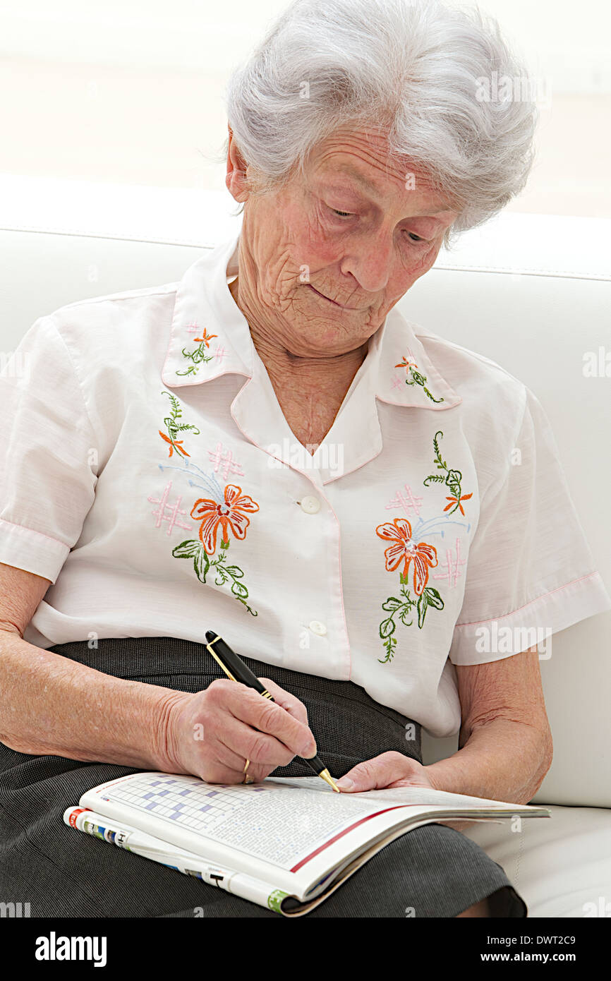 Elderly person doing cr-word puzzle Stock Photo - Alamy