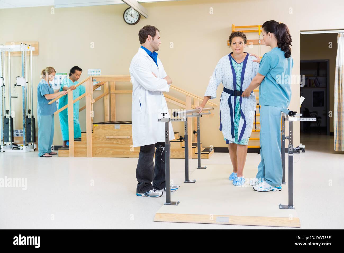 Physical Therapists Assisting Female Patient In Walking Stock Photo - Alamy
