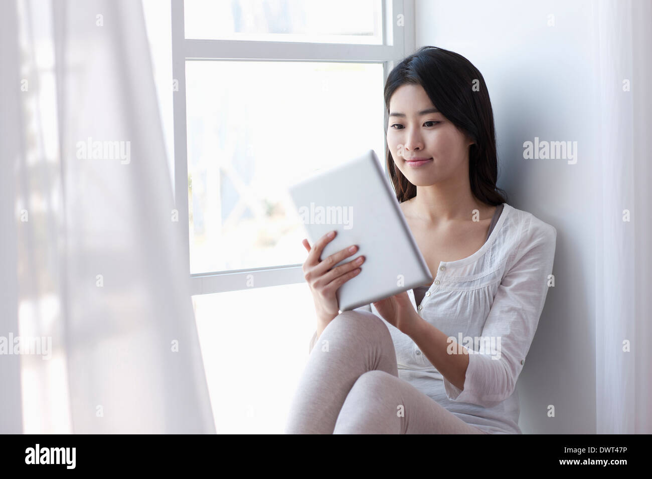 a woman leaning on window and reading a book Stock Photo - Alamy