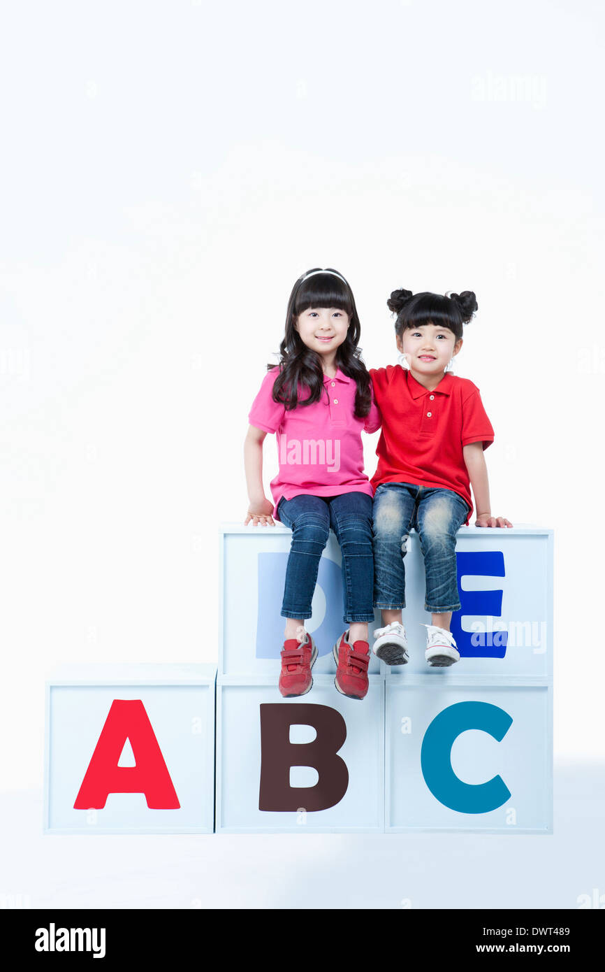 kids sitting on alphabet blocks Stock Photo - Alamy