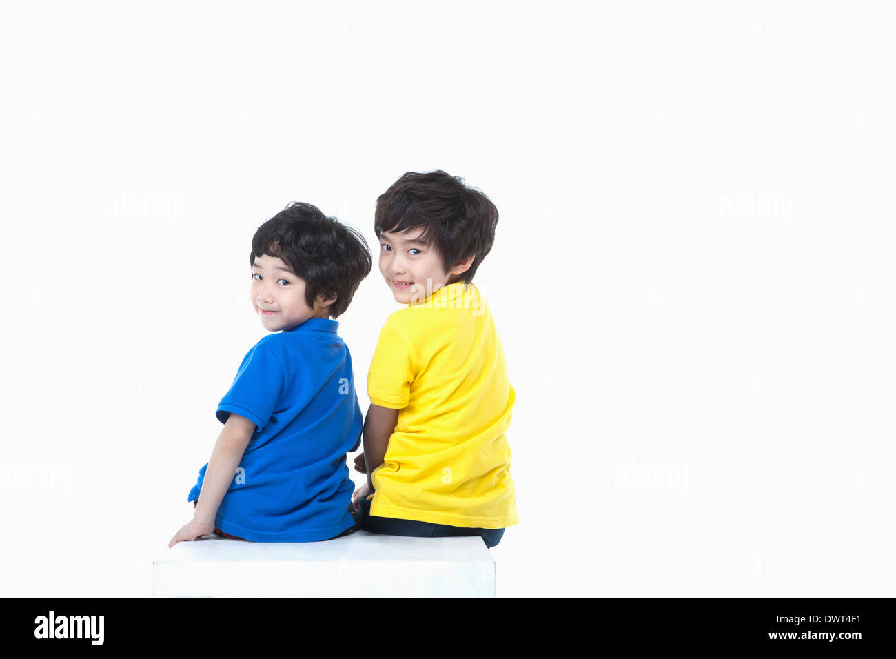 kids looking back sitting on a block Stock Photo - Alamy