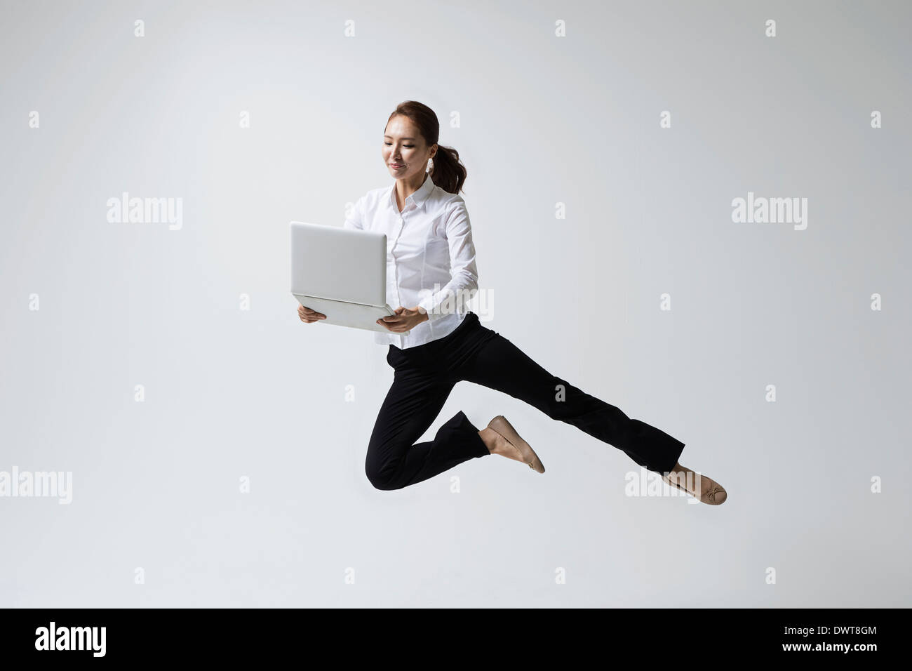a woman making dance poses with a laptop Stock Photo - Alamy