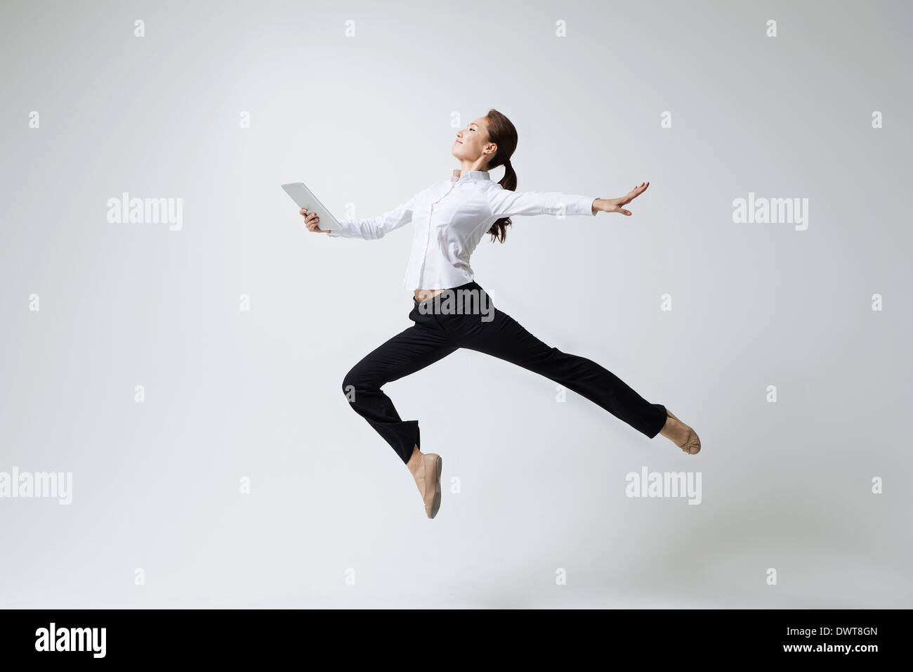 a woman making dance poses with a tablet Stock Photo - Alamy