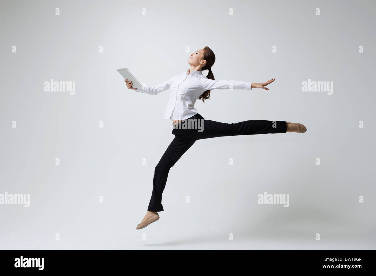 a woman making dance poses with a tablet Stock Photo - Alamy