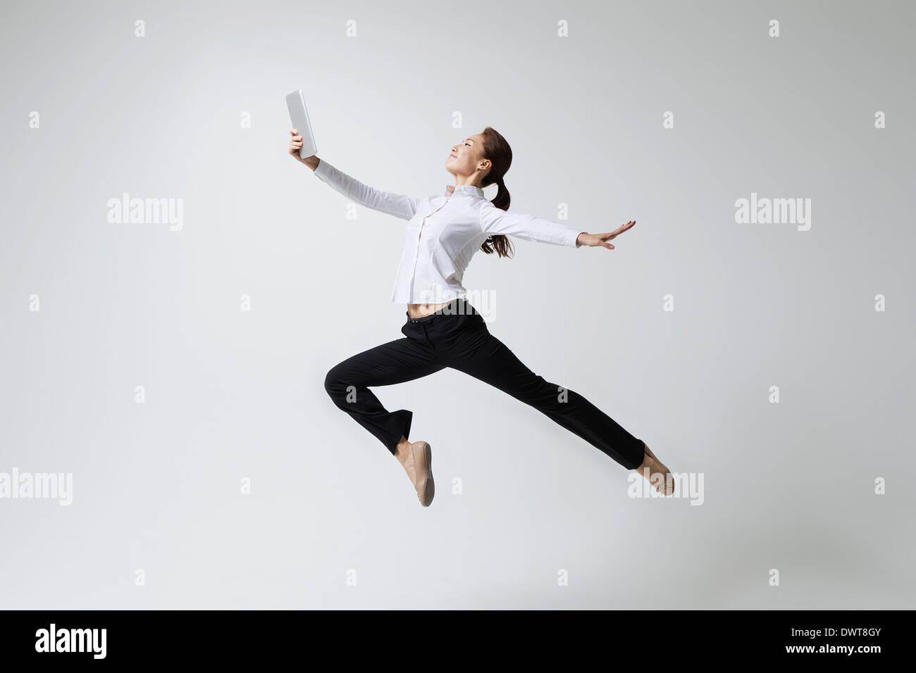 a woman making dance poses with a tablet Stock Photo - Alamy